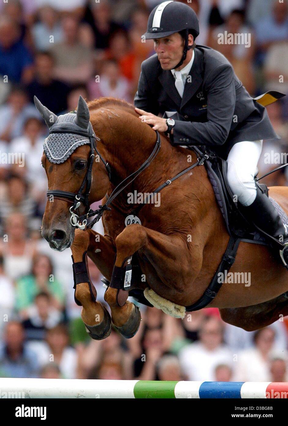 (dpa) - German showjumper Ludger Beerbaum jumps over a barrier with his ...