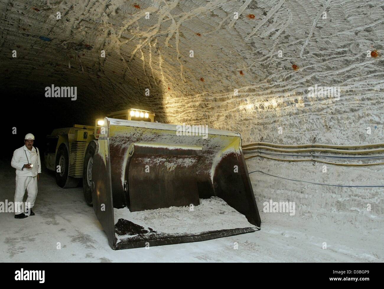(dpa) - A worker stands next to a front bucket excavator in one of the ...