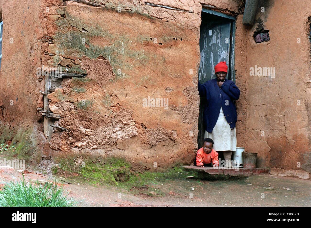 (dpa files) - An old woman with her crawling grandchild stands in front ...