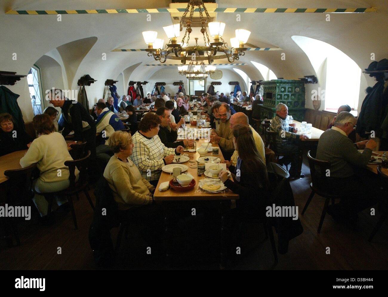 (dpa) - Numerous guests sit together alongside rustic tables in the ...