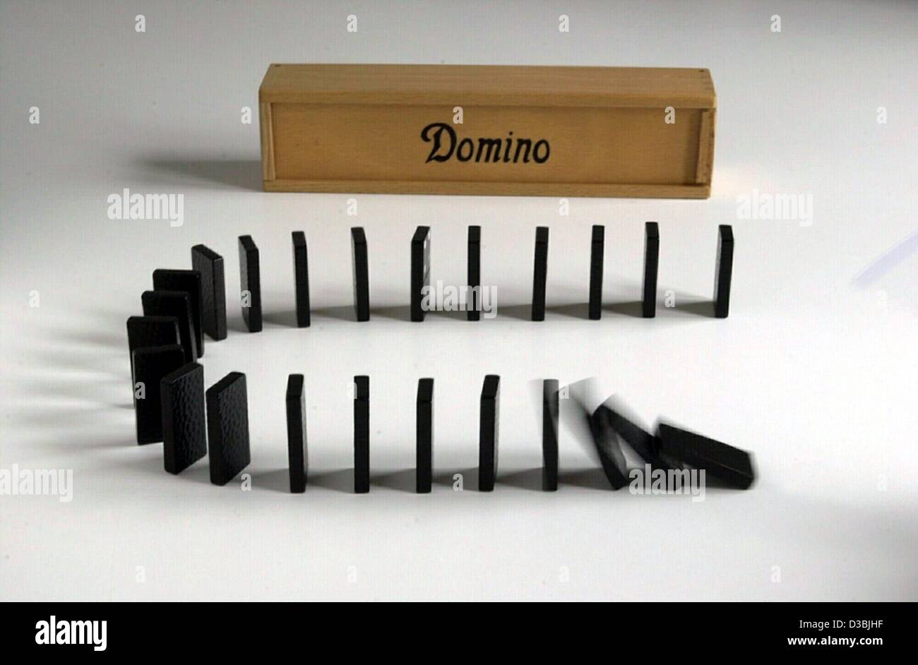 (dpa) - A set of dominoes standing in a row are falling one after ...