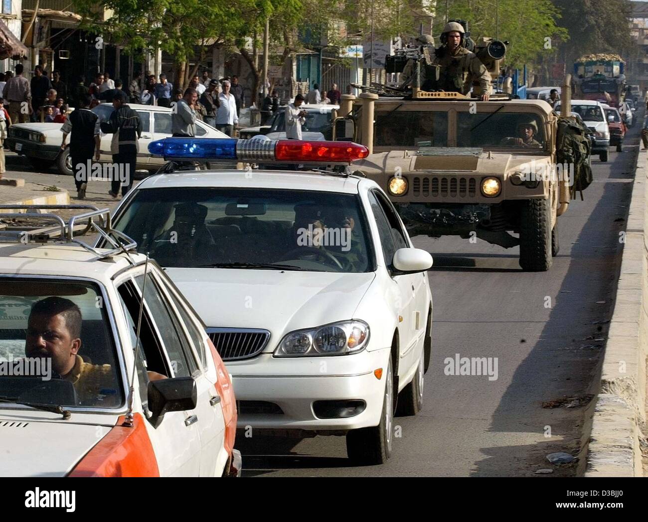 (dpa) - An Iraqi police car patrols the streets of Baghdad followed by ...