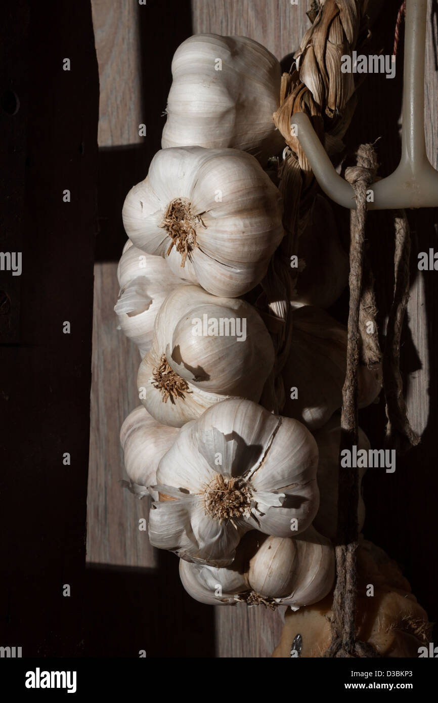 Hanging garlic against a wooden background Stock Photo - Alamy