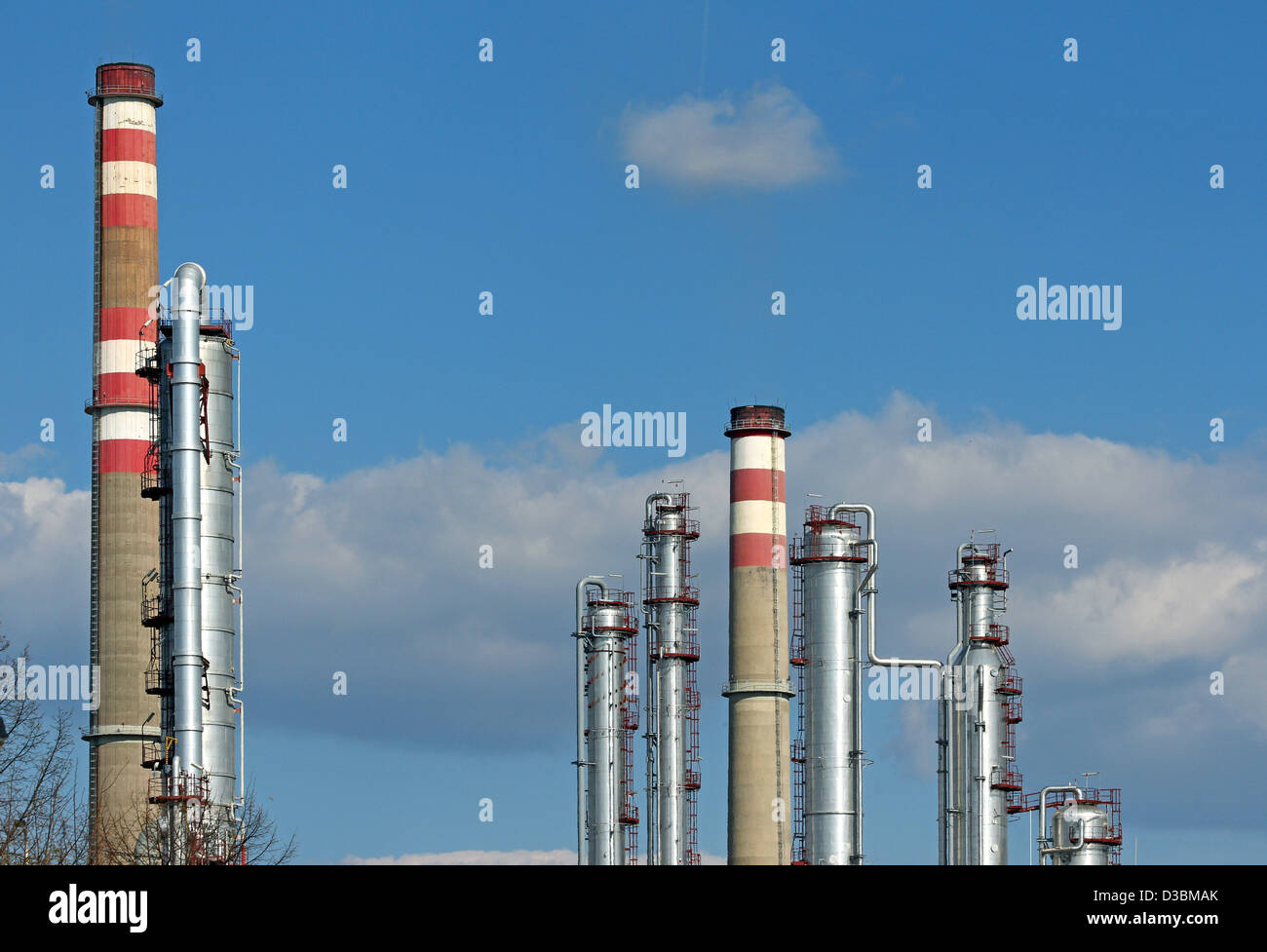 lot of different chimneys of oil refinery and blue sky Stock Photo - Alamy
