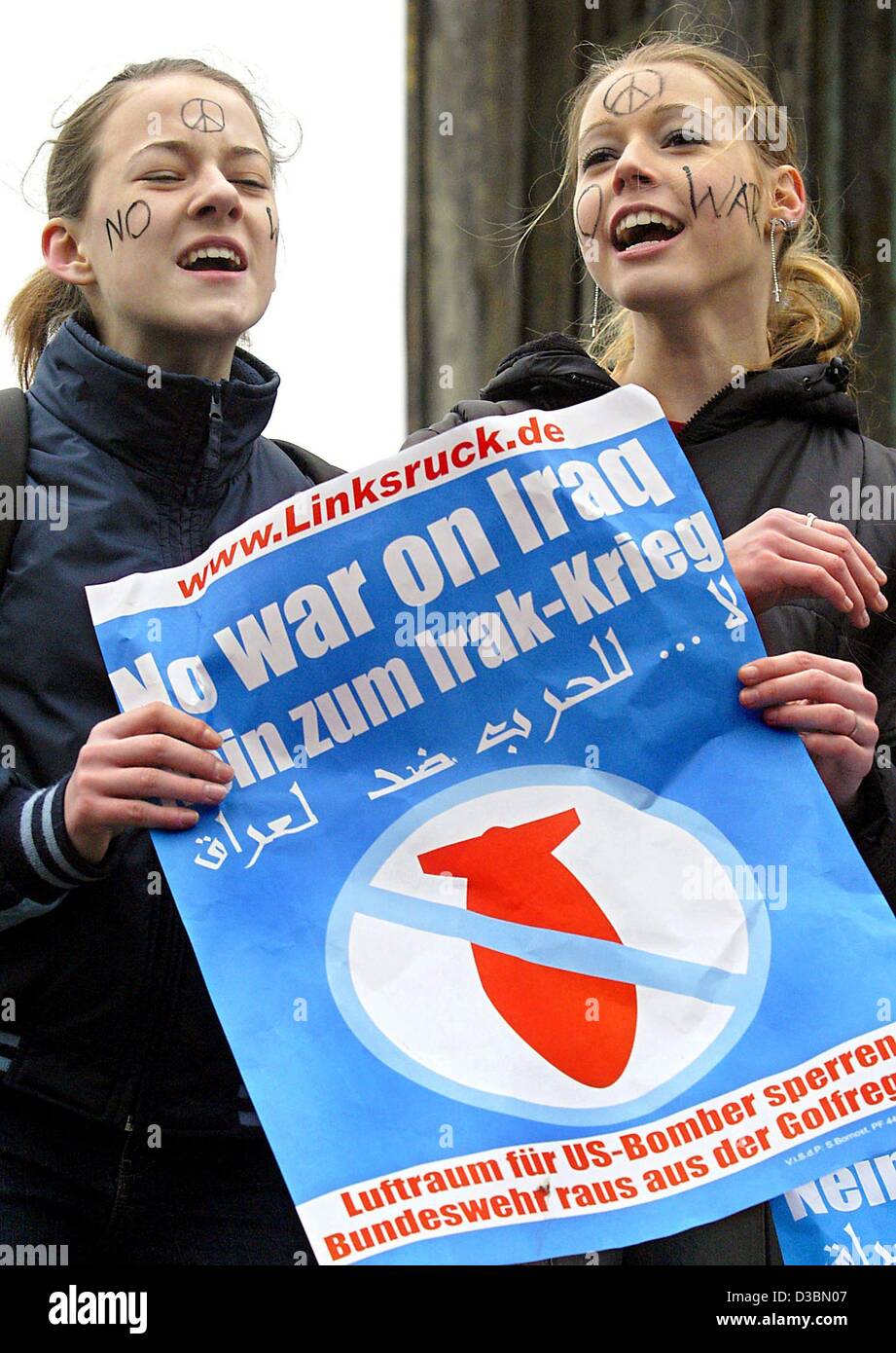 (dpa) - Two girls hold up a trilingual poster as several thousand ...