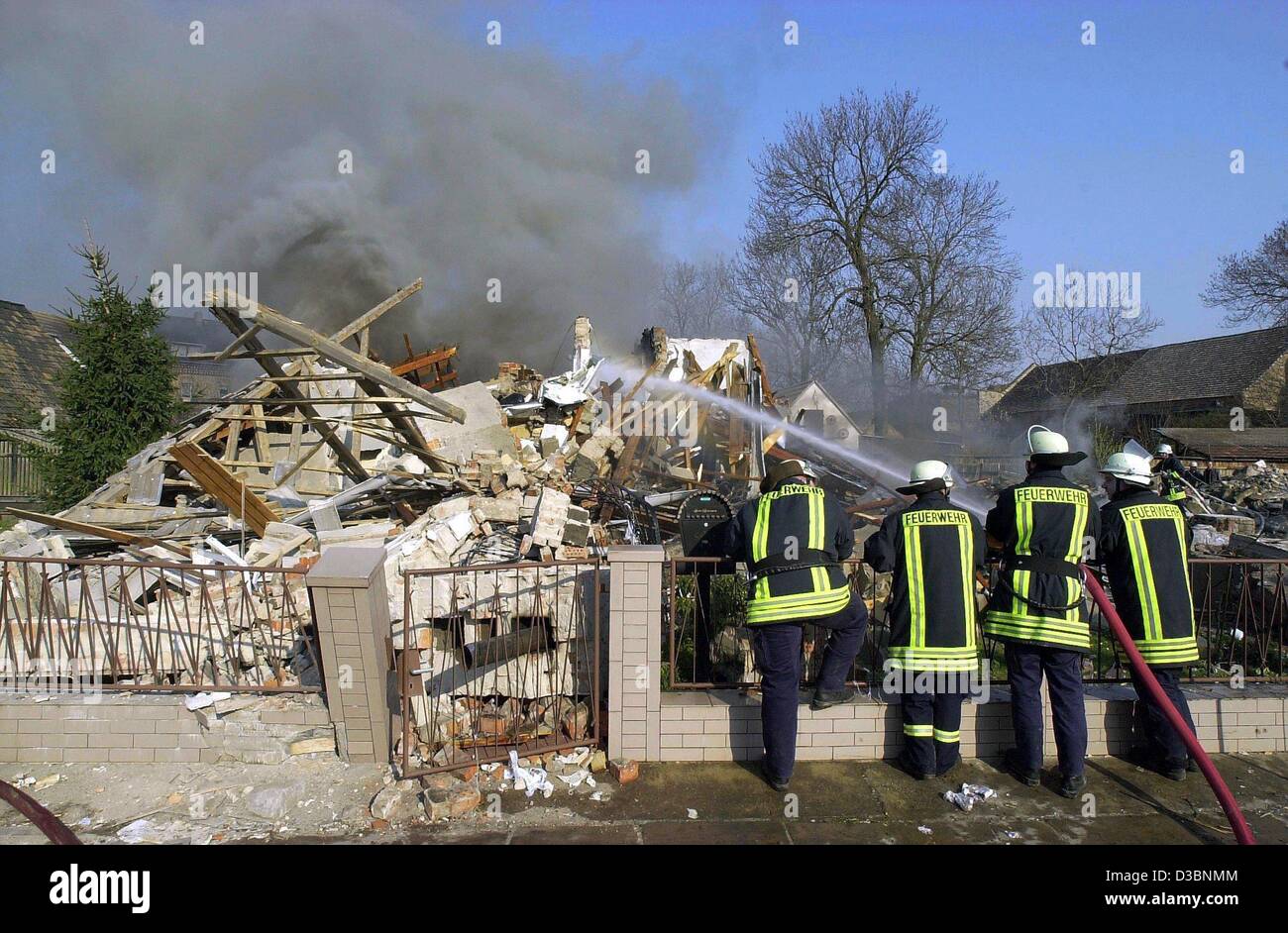 (dpa) - Firemen water a smouldering fire in a family home after a ...