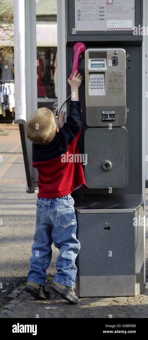 (dpa) - A little chap has to stretch to get the receiver of a telephone ...