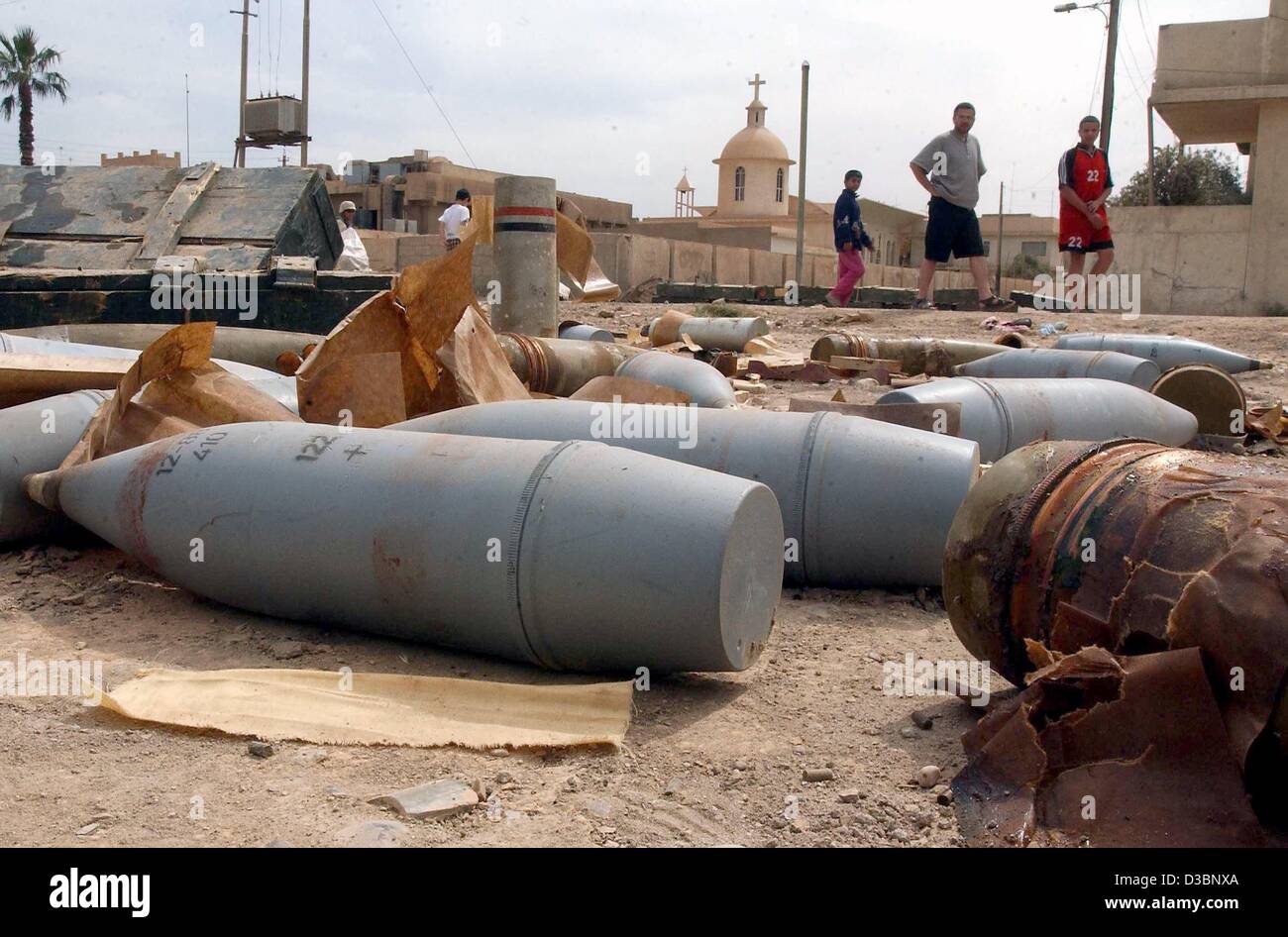 (dpa) - Iraqis look at artillery ammunition left behind by the Iraqi ...