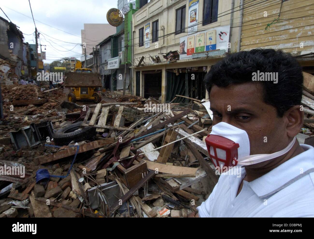 (dpa) - A Sri Lankan wearing a face mask looks for bodies in the ...