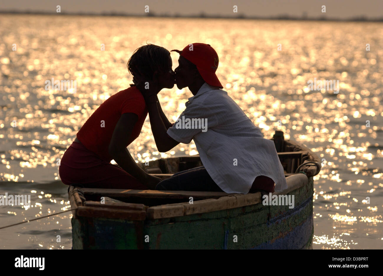 (dpa files) A young couple shares a kiss in the evening sun on a ...