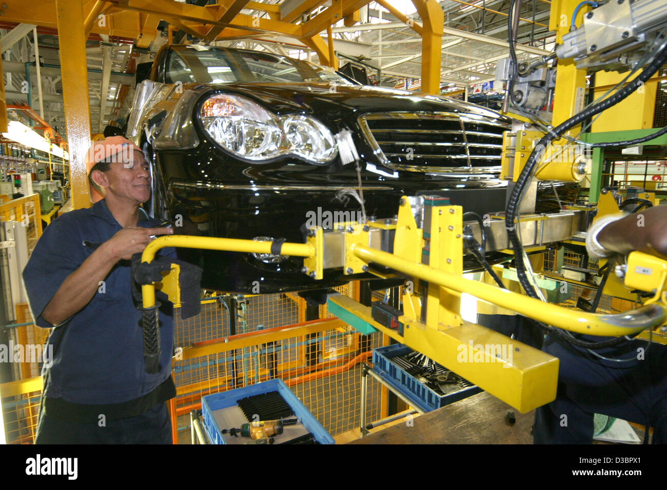 (dpa) - An employee works on a Mercedes car at the DaimlerChrysler ...