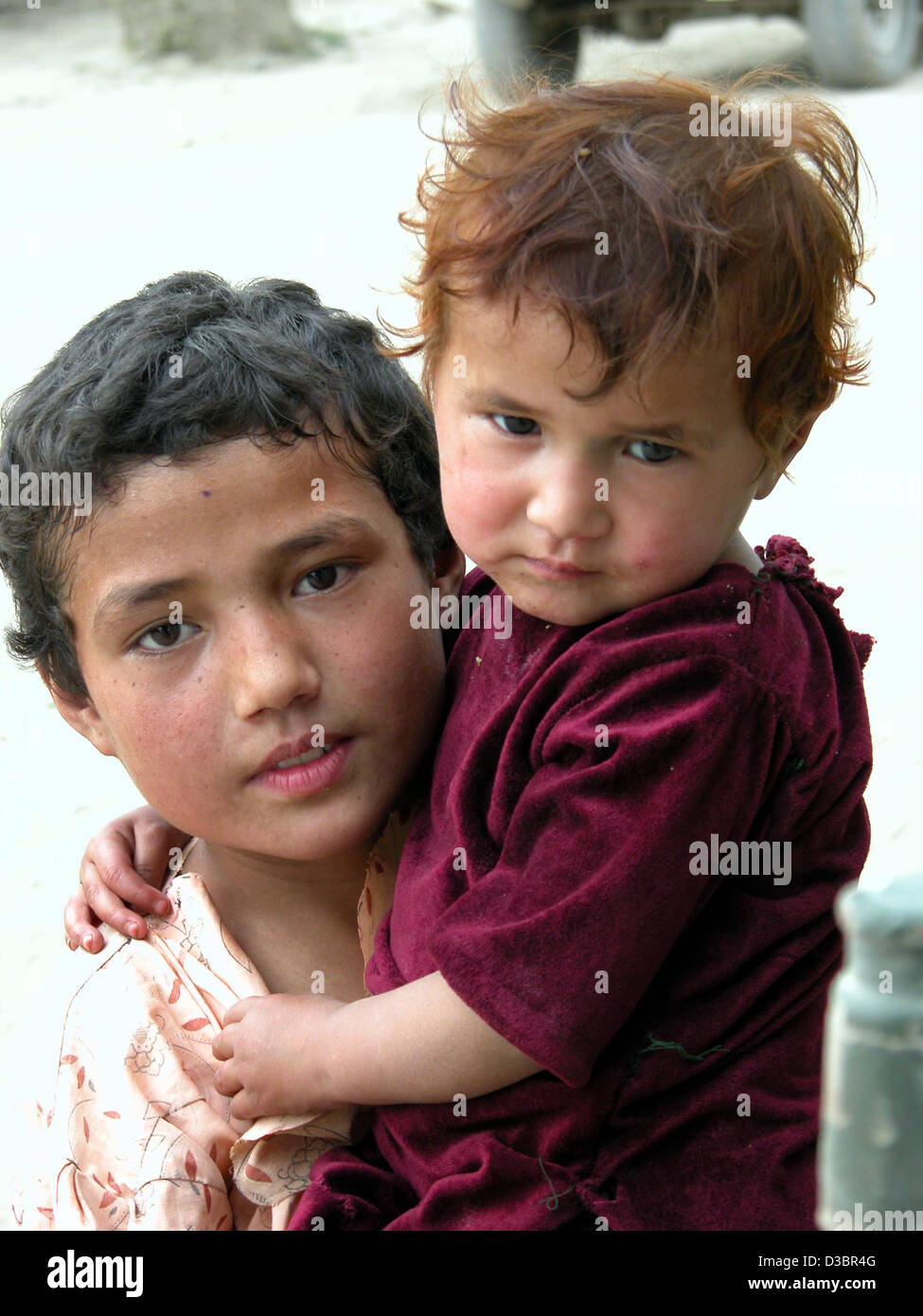 (dpa) - A small Afghan boy carries his little sister in Eman Saheb ...