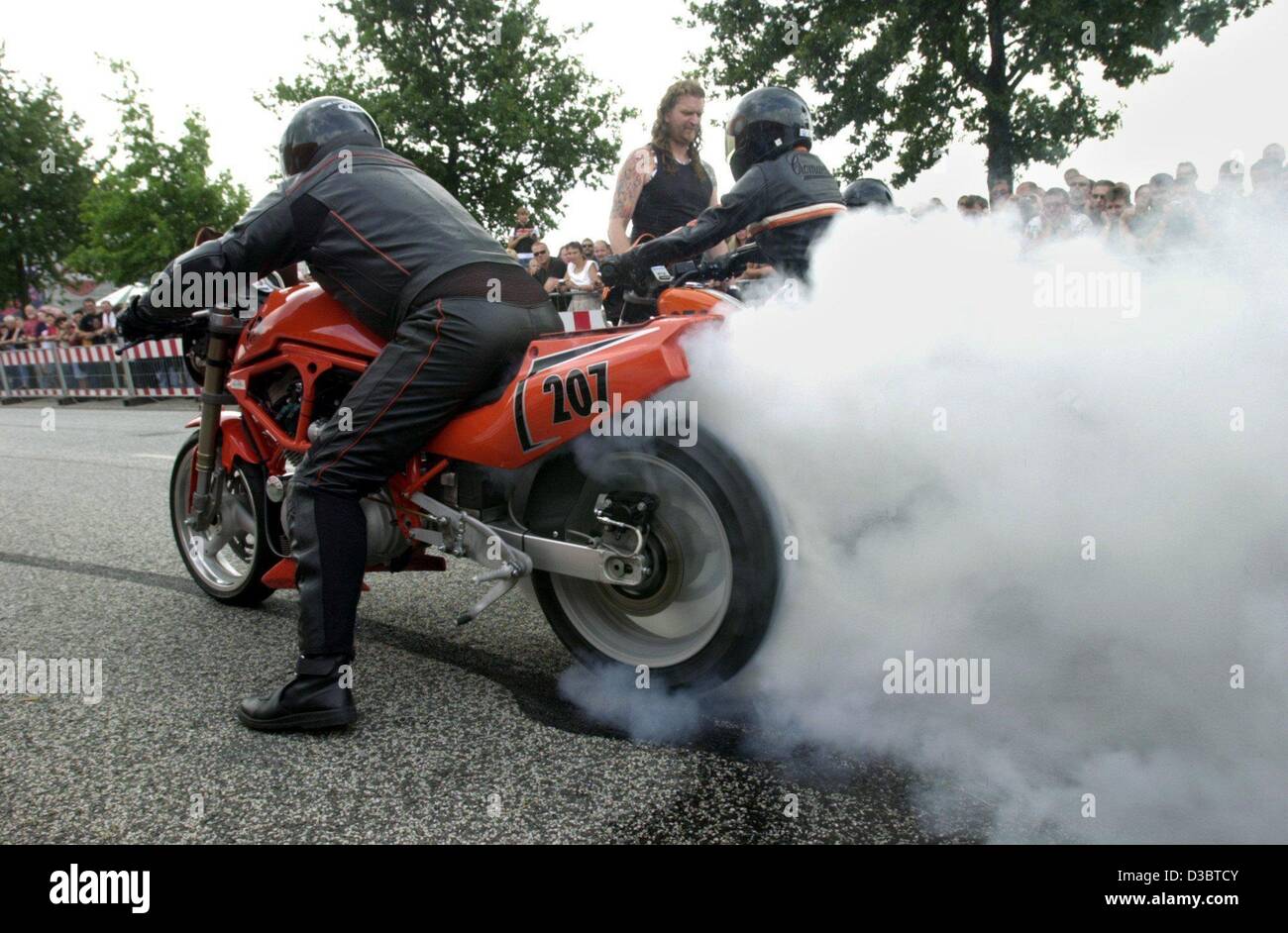 (dpa) - A stuntdriver produces a cloud of smoke with his Harley ...
