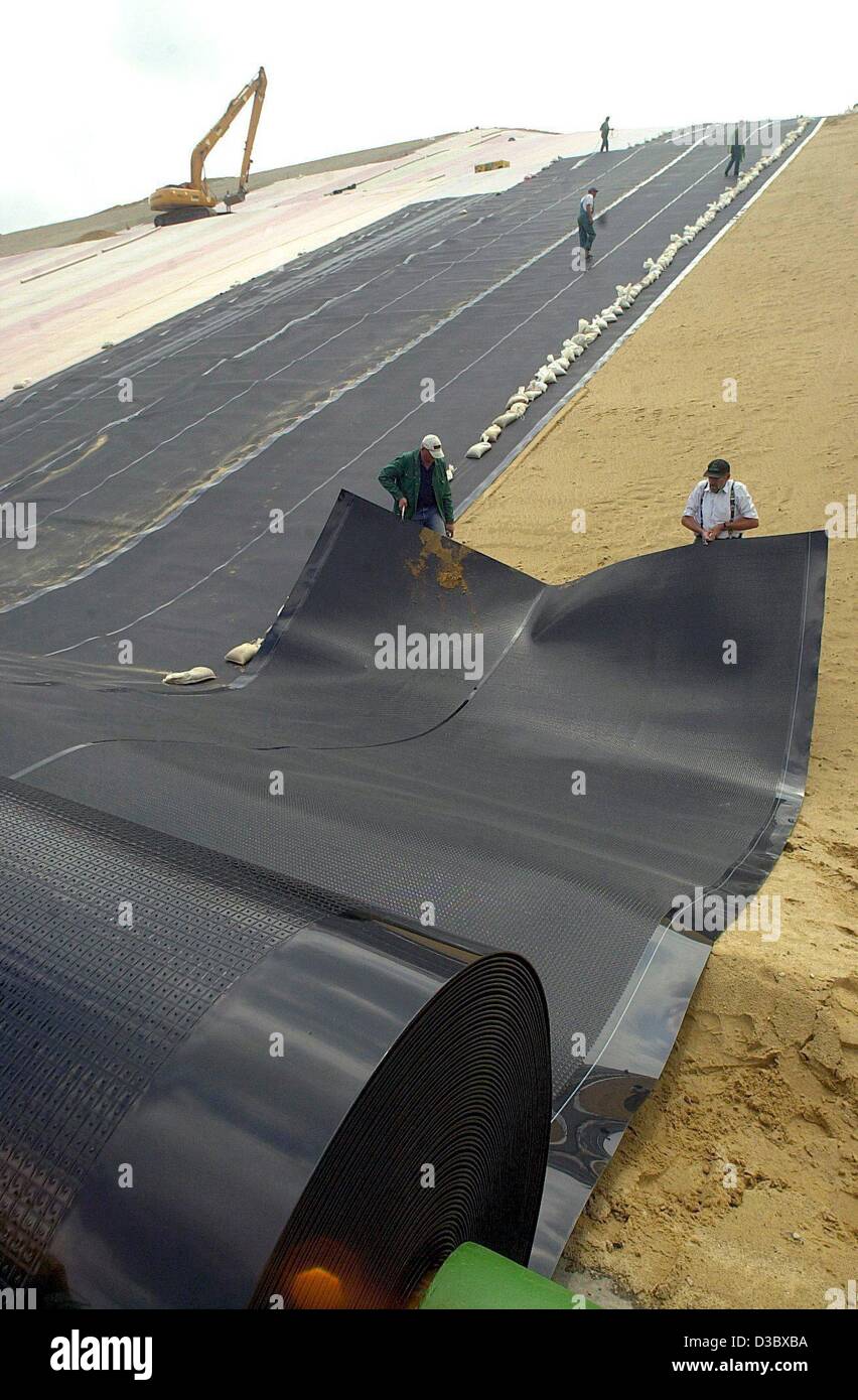 (dpa) - Workers spread out a synthetic plane at the waste disposal site ...