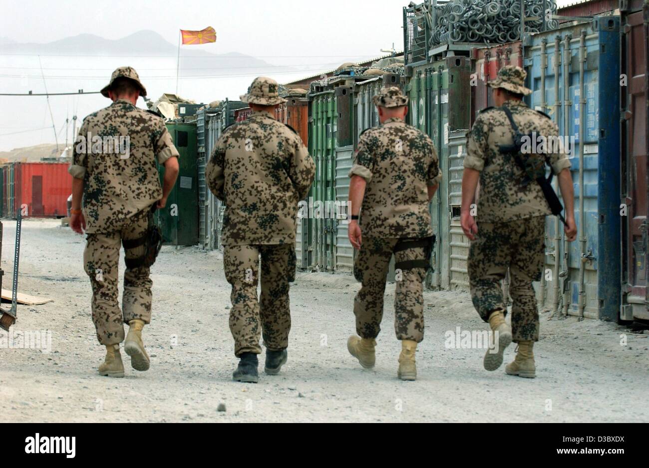 (dpa) - A group of German soldiers walk through the dusty streets of ...