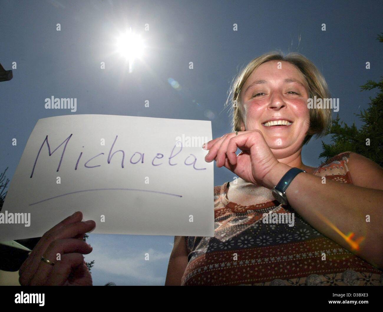 (dpa) - Michaela Simon smiles while she holds up a white piece of paper ...
