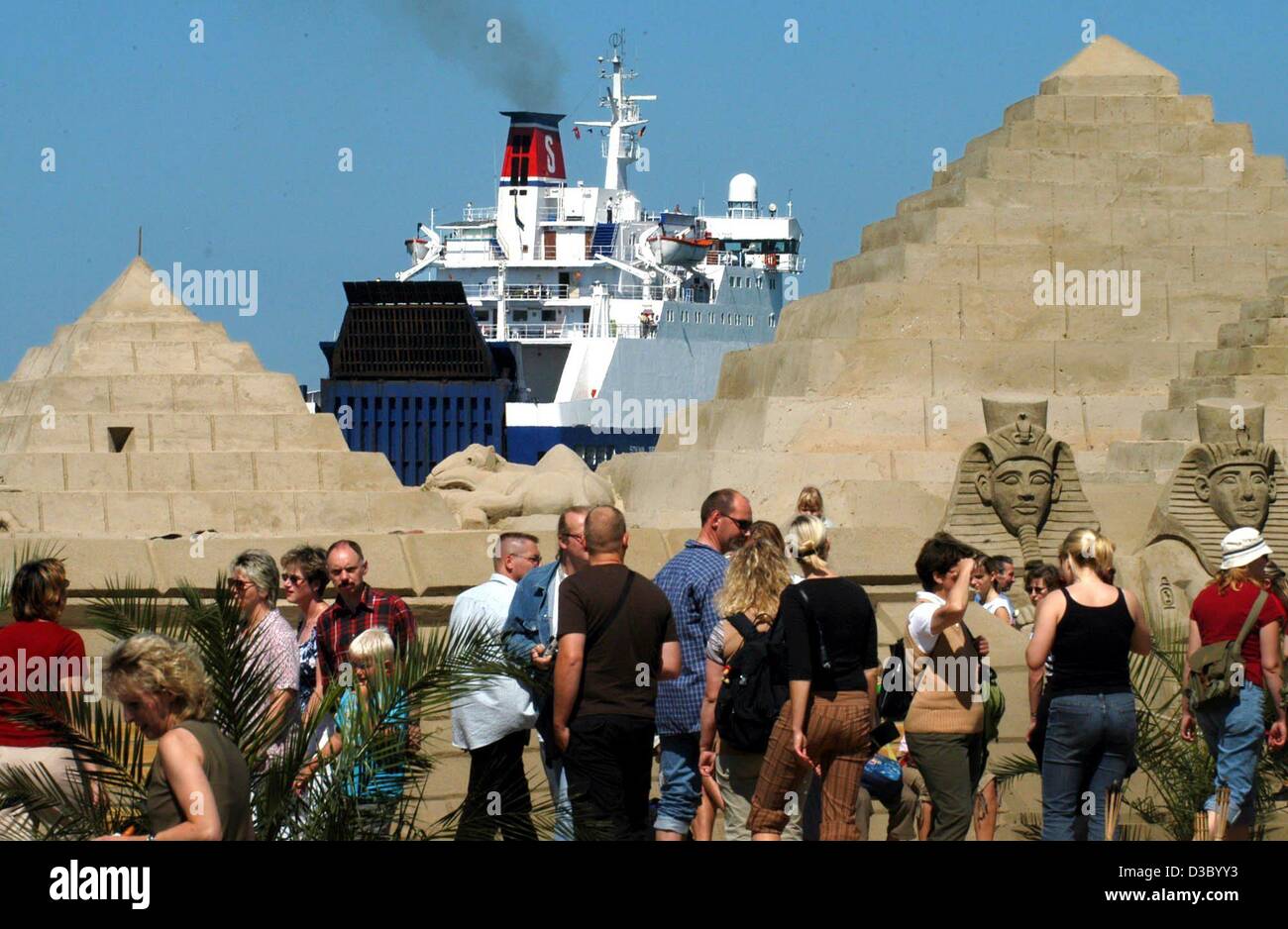 (dpa) - Visitors marvel at the Egyptian pyramids made of sand on a ...