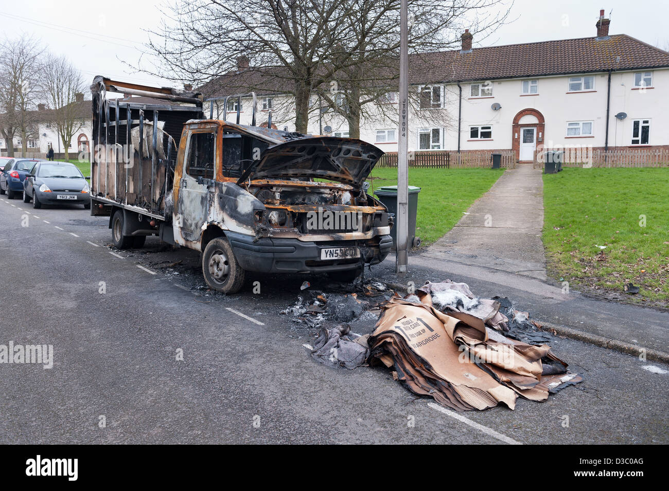 burnt vandalized van near end of grass verge footpath leading to white ...