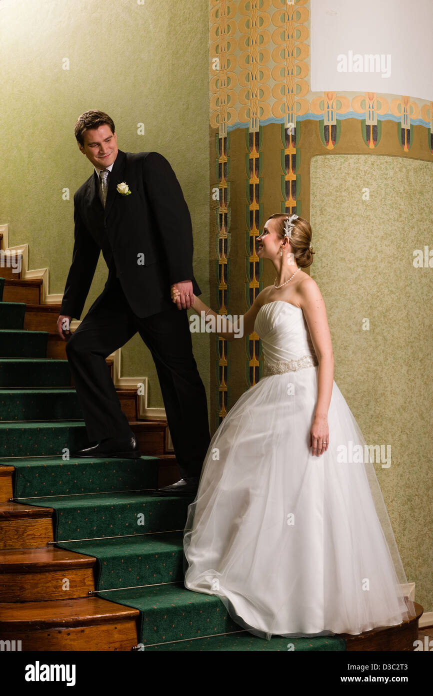 Bride and groom are going together on upstairs Stock Photo - Alamy