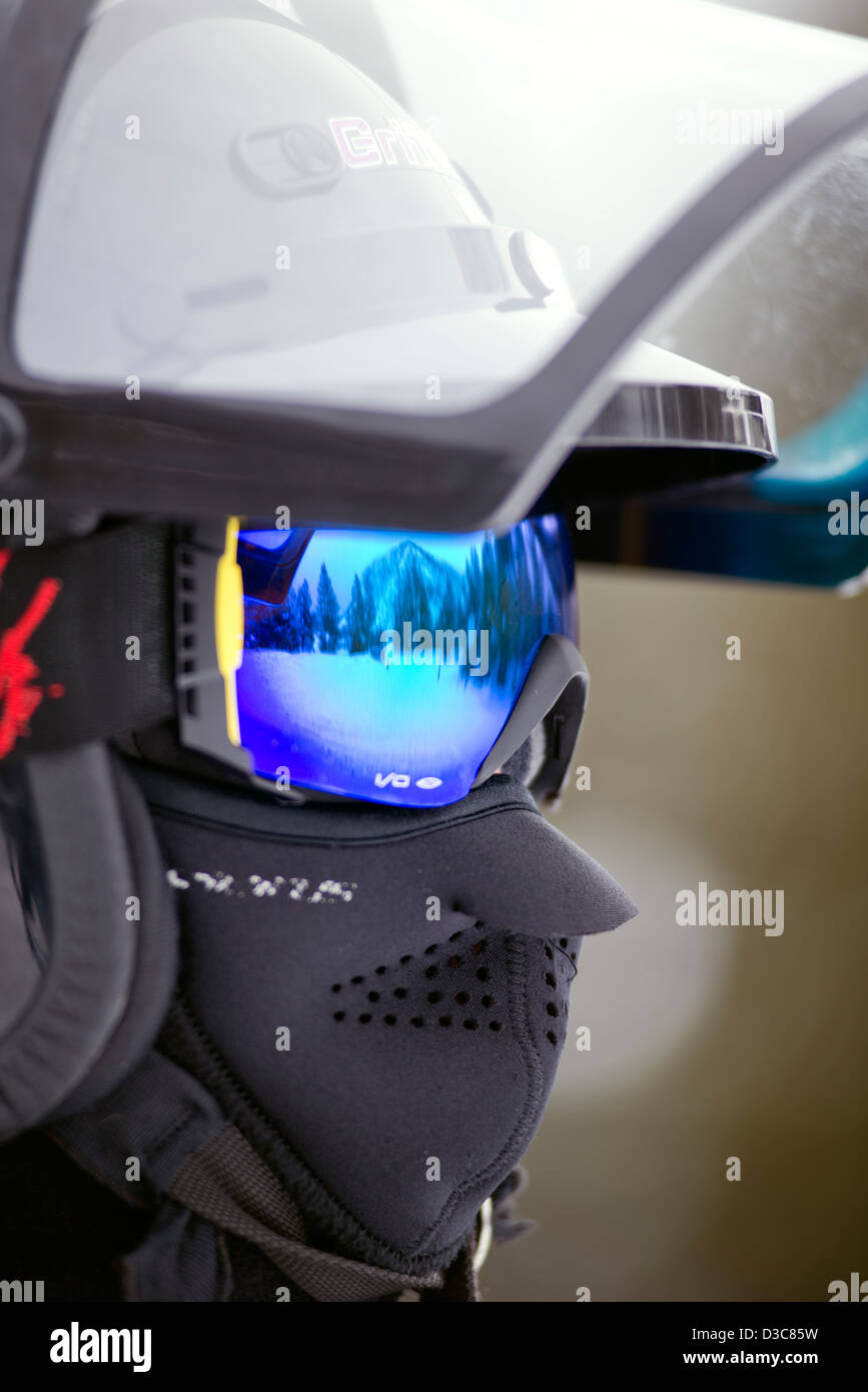 Man wearing protective headgear, face mask and reflective goggles while ...