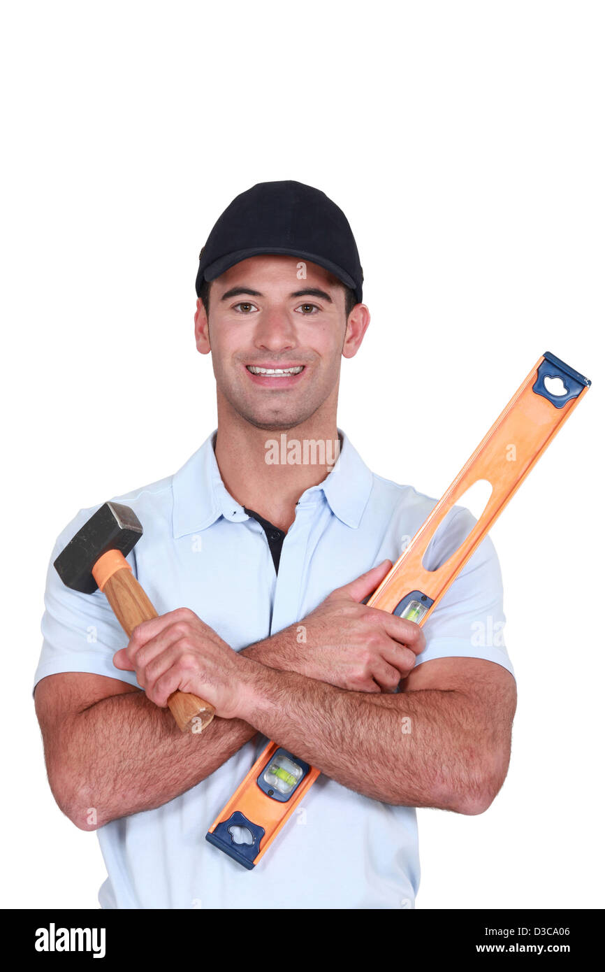 A handyman with a hammer and a level Stock Photo - Alamy