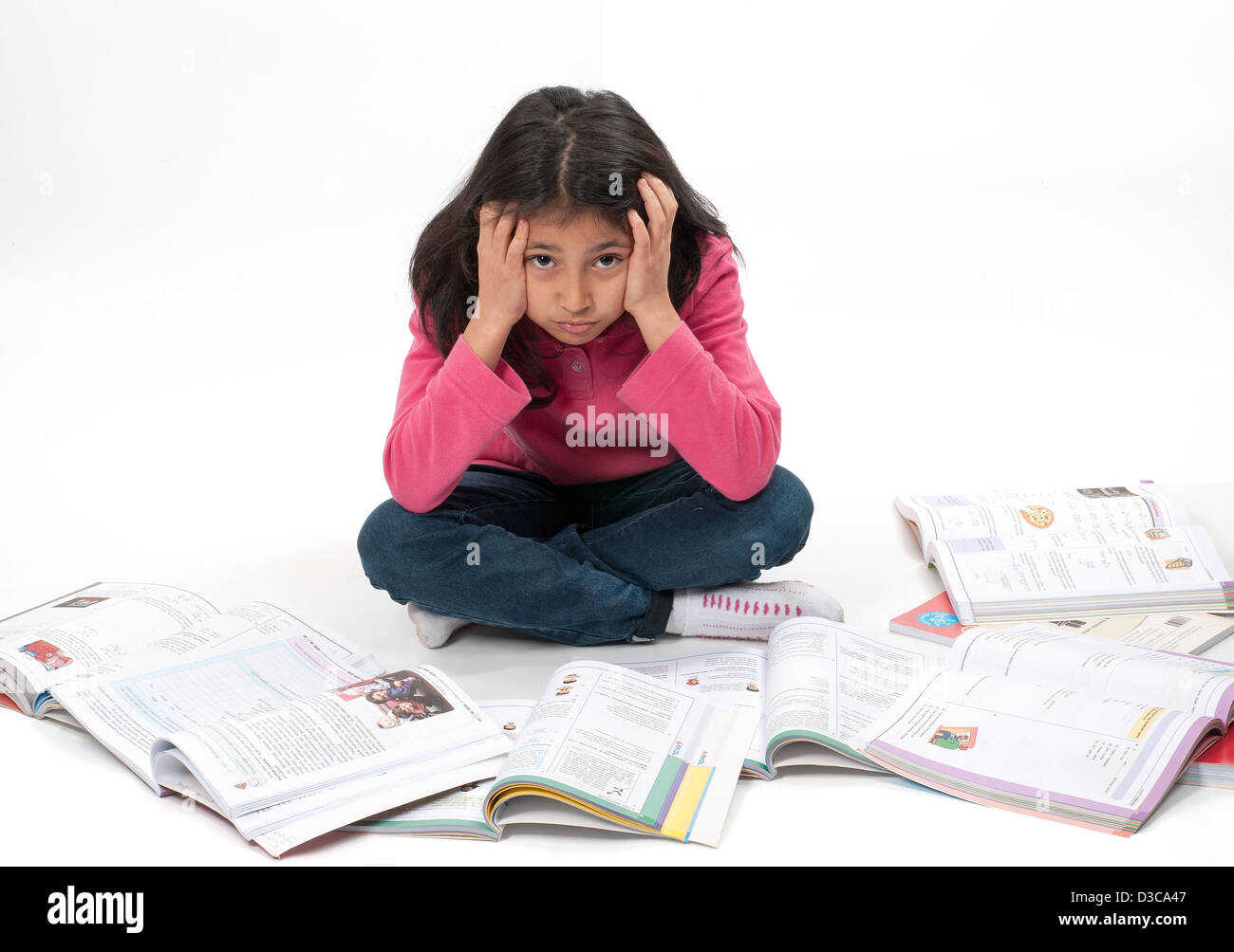 The little girl is reading a book on white background. She is bored ...