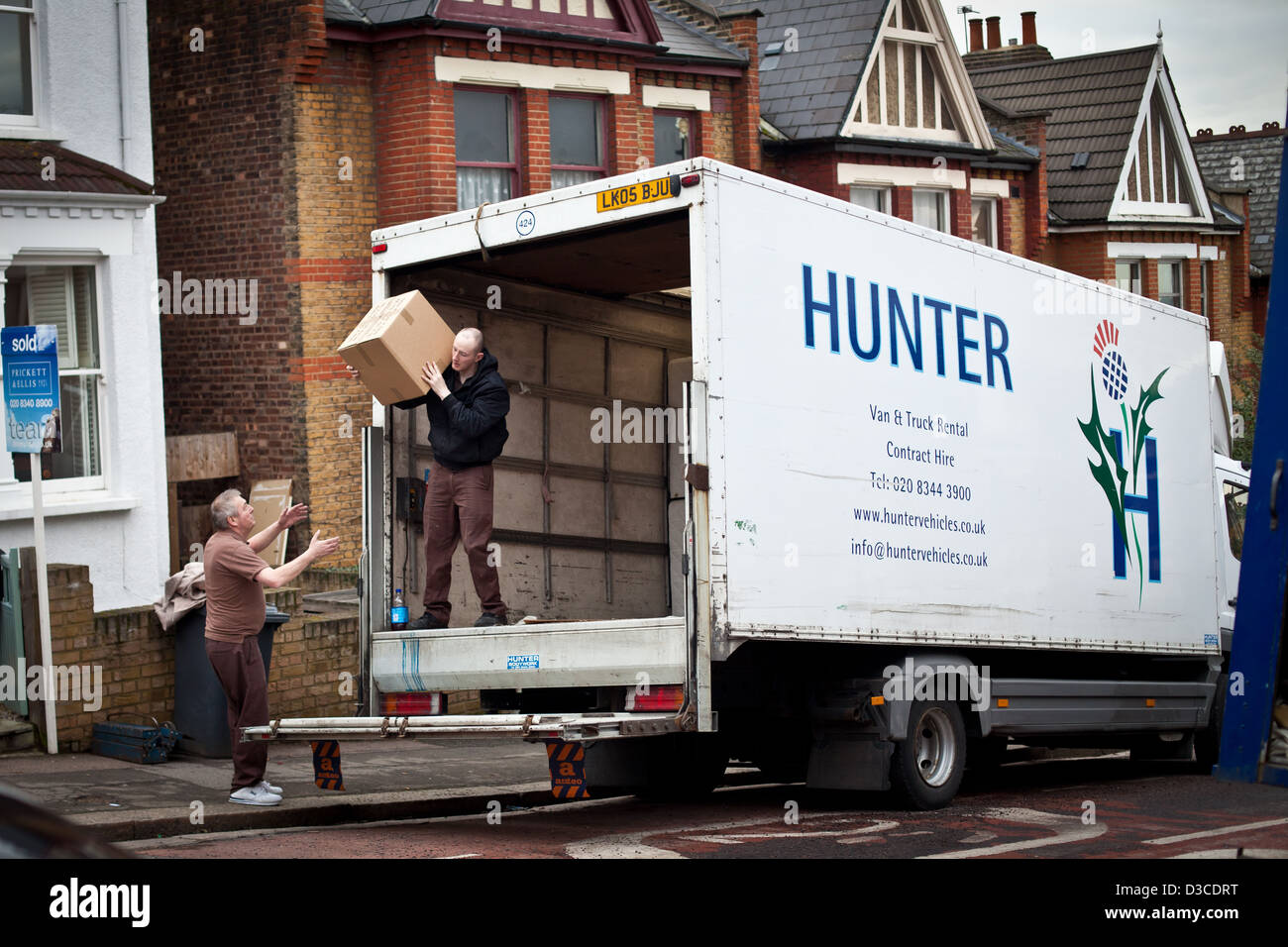 Removal men unloading van Stock Photo - Alamy