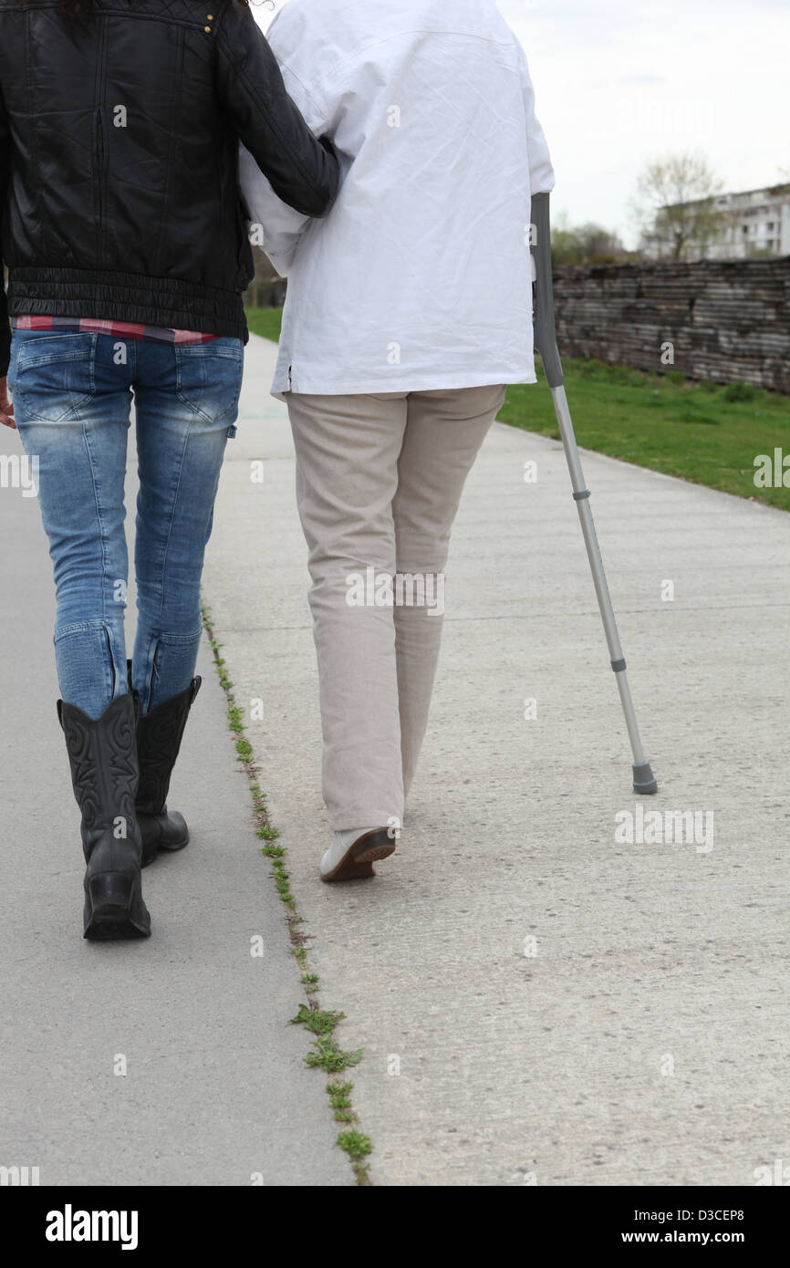 woman helping senior to walk Stock Photo - Alamy