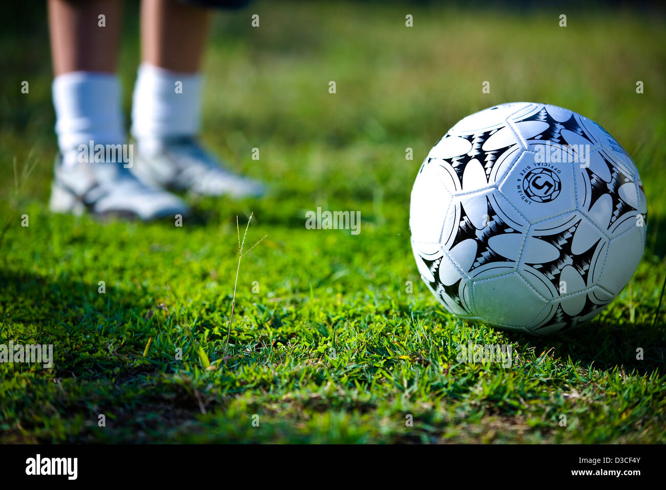 Sports field with ground level image of a football and person in ...