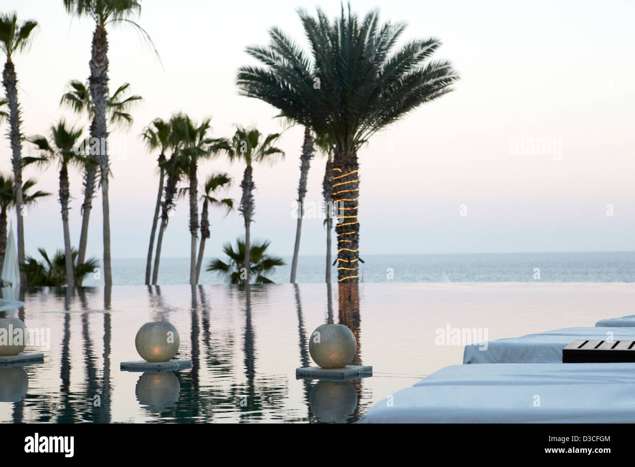 Resort infinity pool at sunset dusk with floating lanterns and lights ...