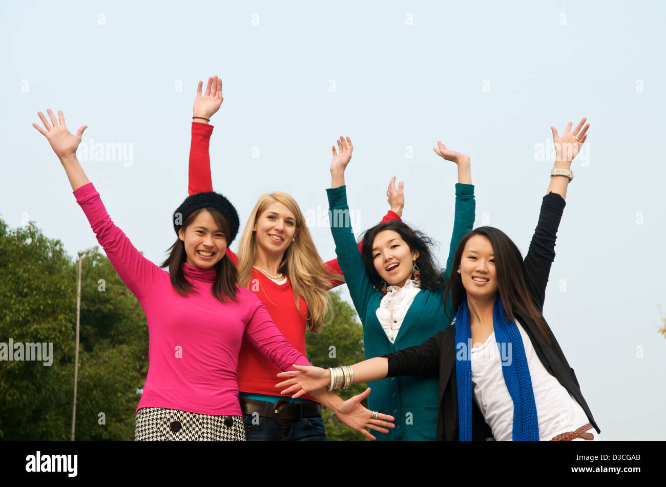 Group of 4 female students outdoor cheering Stock Photo - Alamy