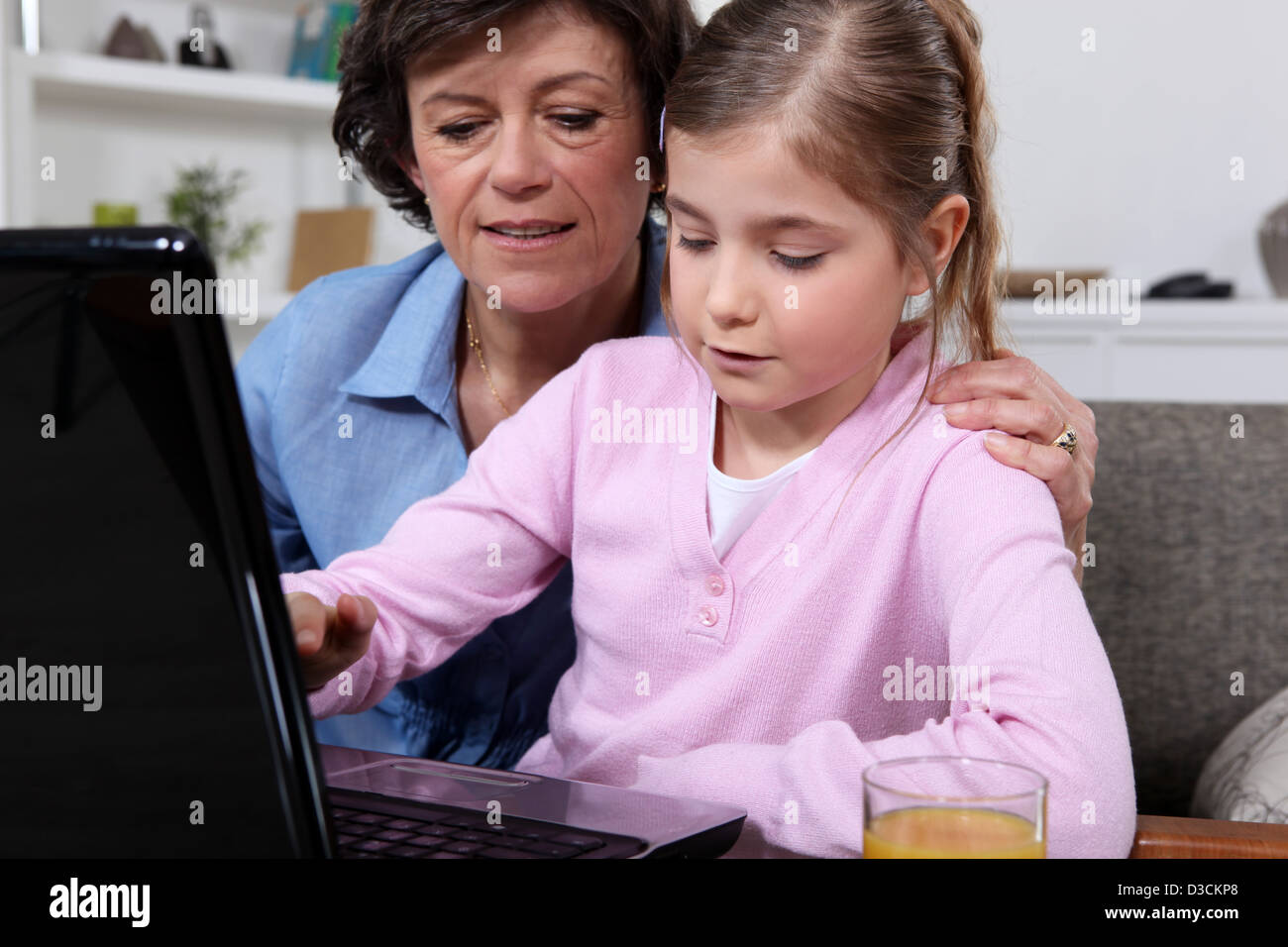 Senior woman and little girl working on laptop computer Stock Photo - Alamy