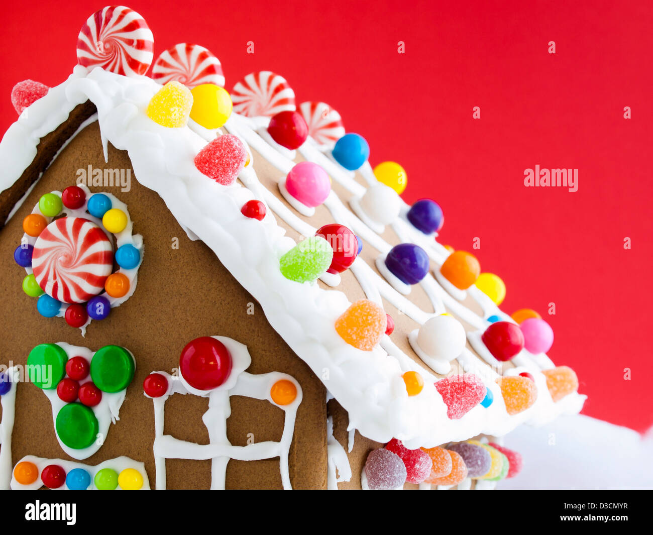 Decorated gingerbread house on red background Stock Photo - Alamy