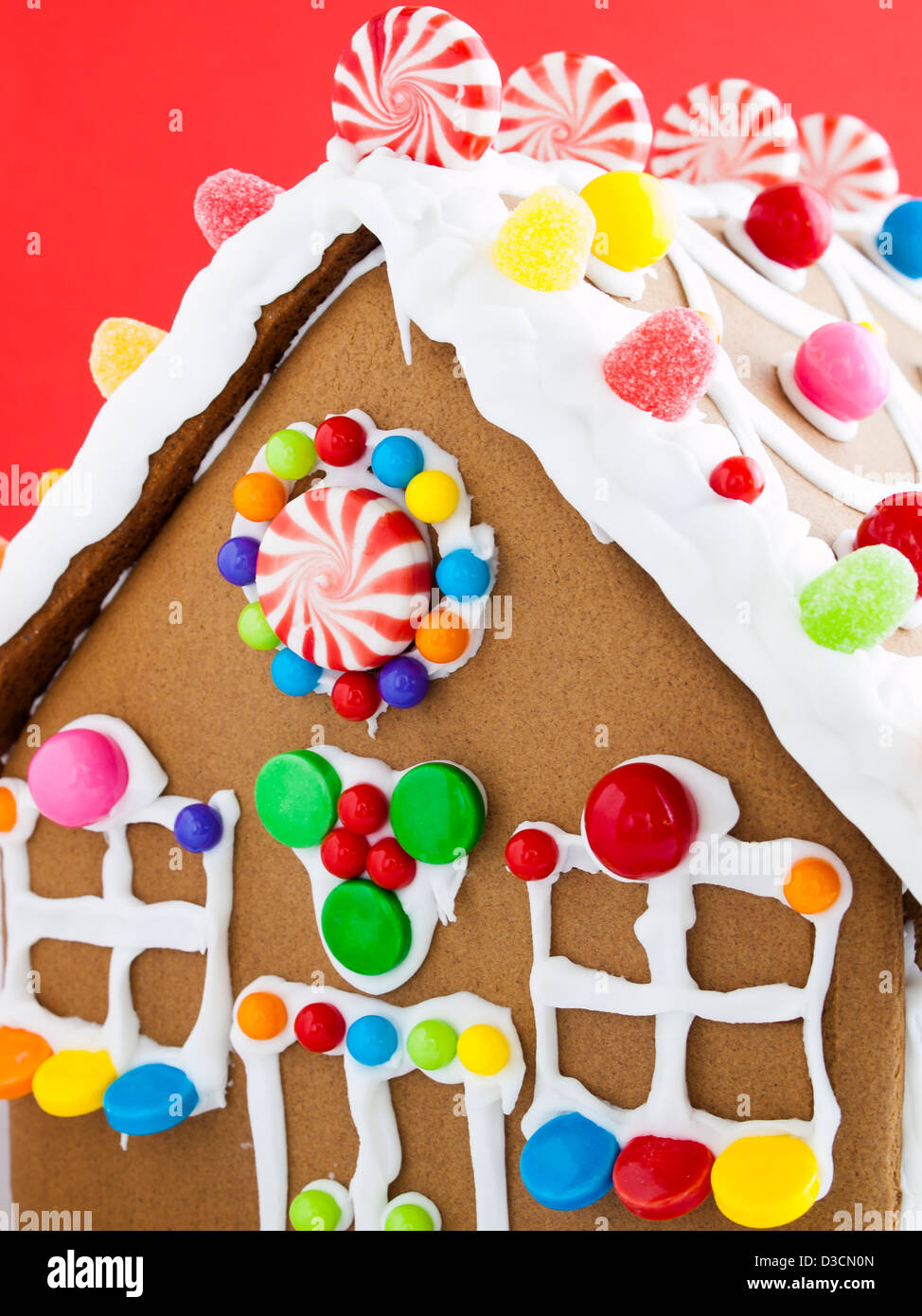 Decorated gingerbread house on red background Stock Photo - Alamy