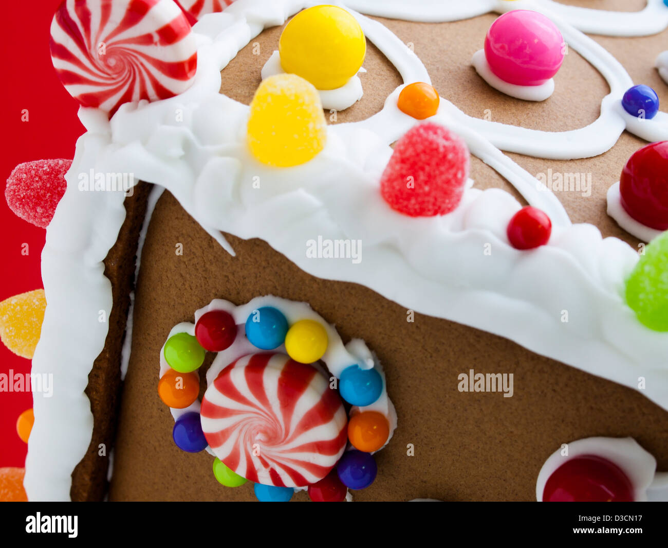 Decorated gingerbread house on red background Stock Photo - Alamy