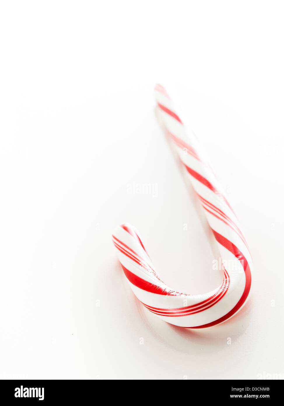 White and red peppermint candy cane on white background Stock Photo - Alamy