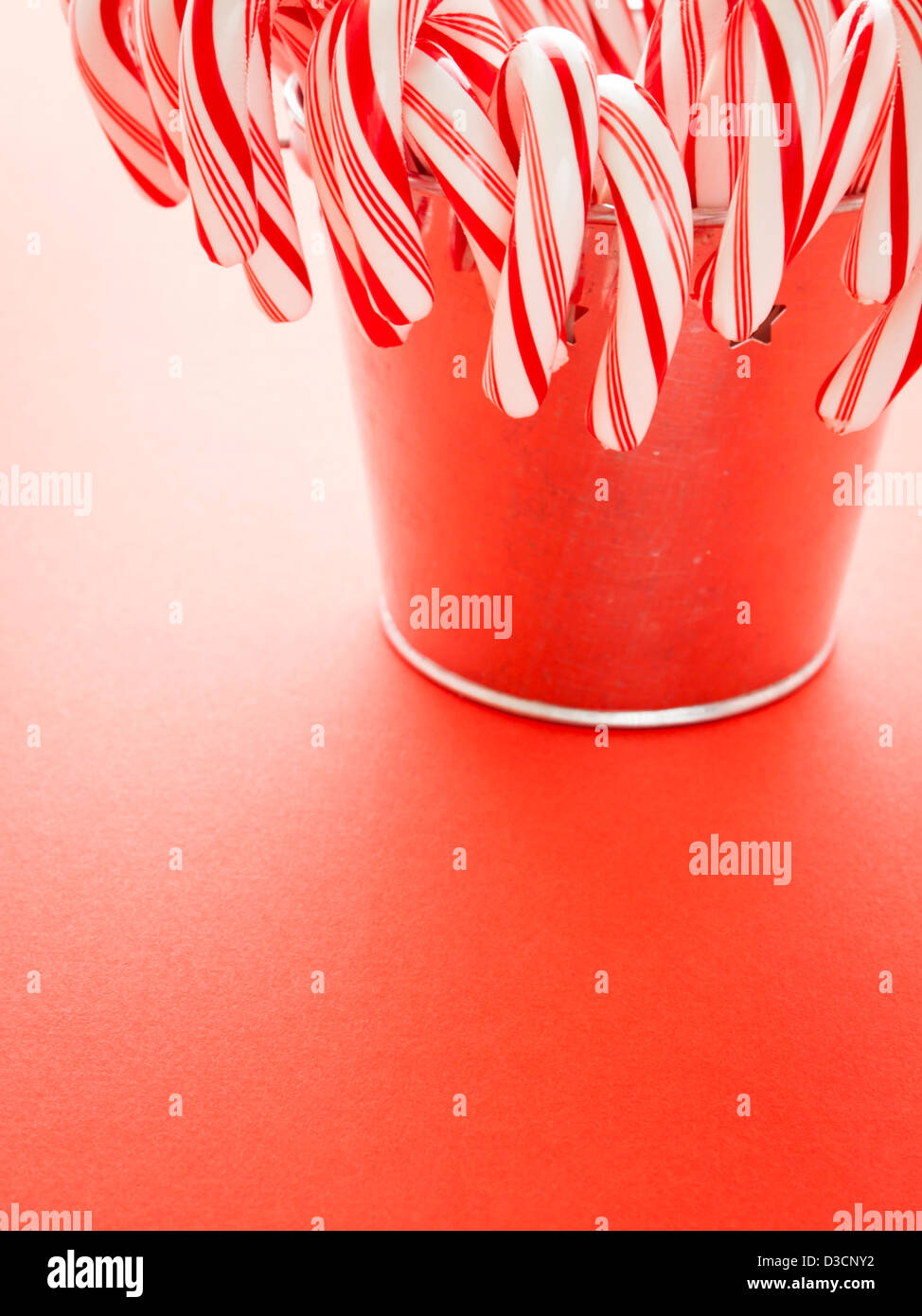 White and red peppermint candy canes in bucket on red background Stock ...