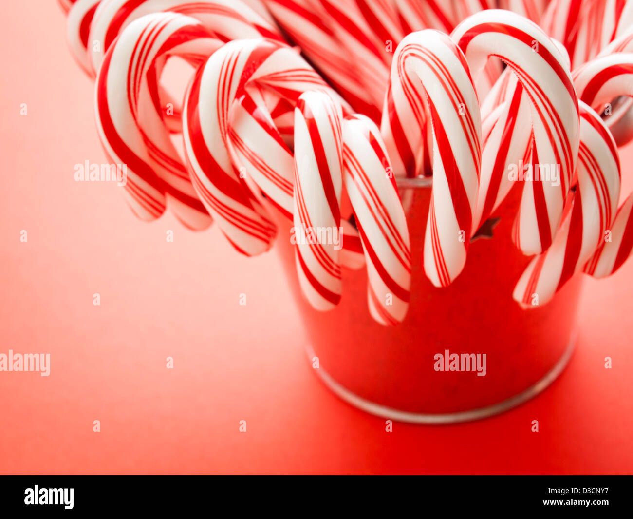 White and red peppermint candy canes in bucket on red background Stock ...