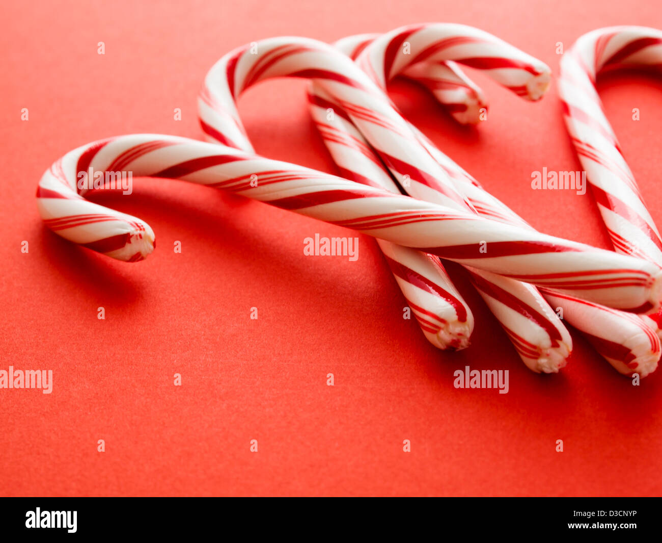 White and red peppermint candy canes on red background Stock Photo - Alamy