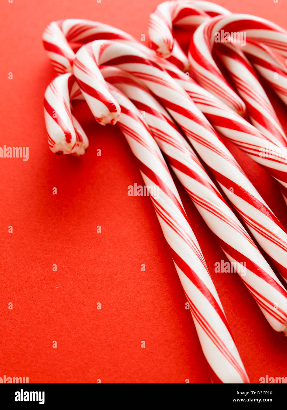 White and red peppermint candy canes on red background Stock Photo - Alamy