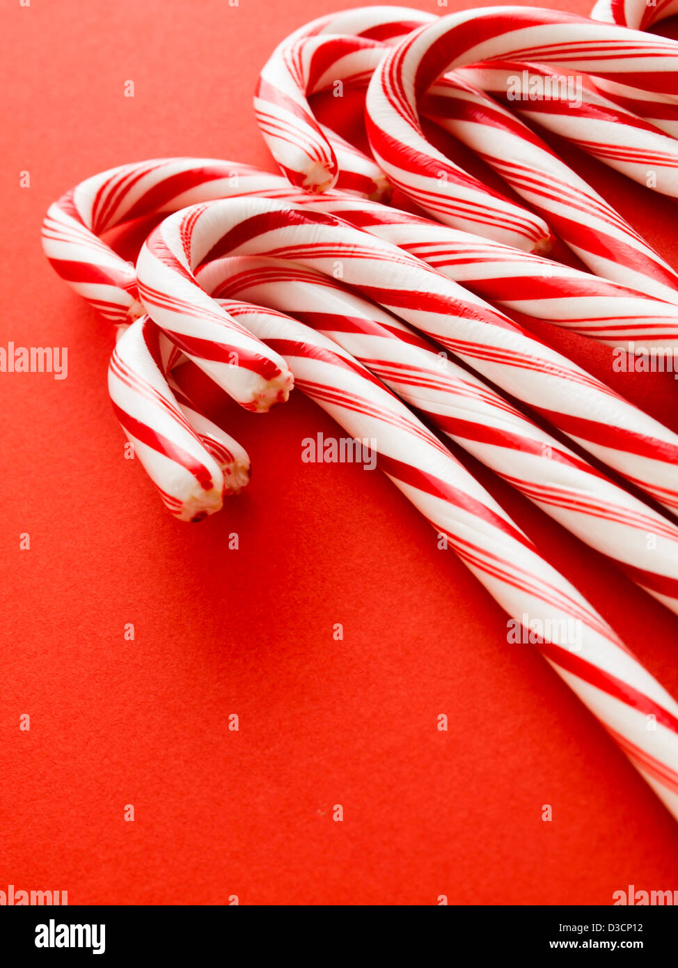 White and red peppermint candy canes on red background Stock Photo - Alamy