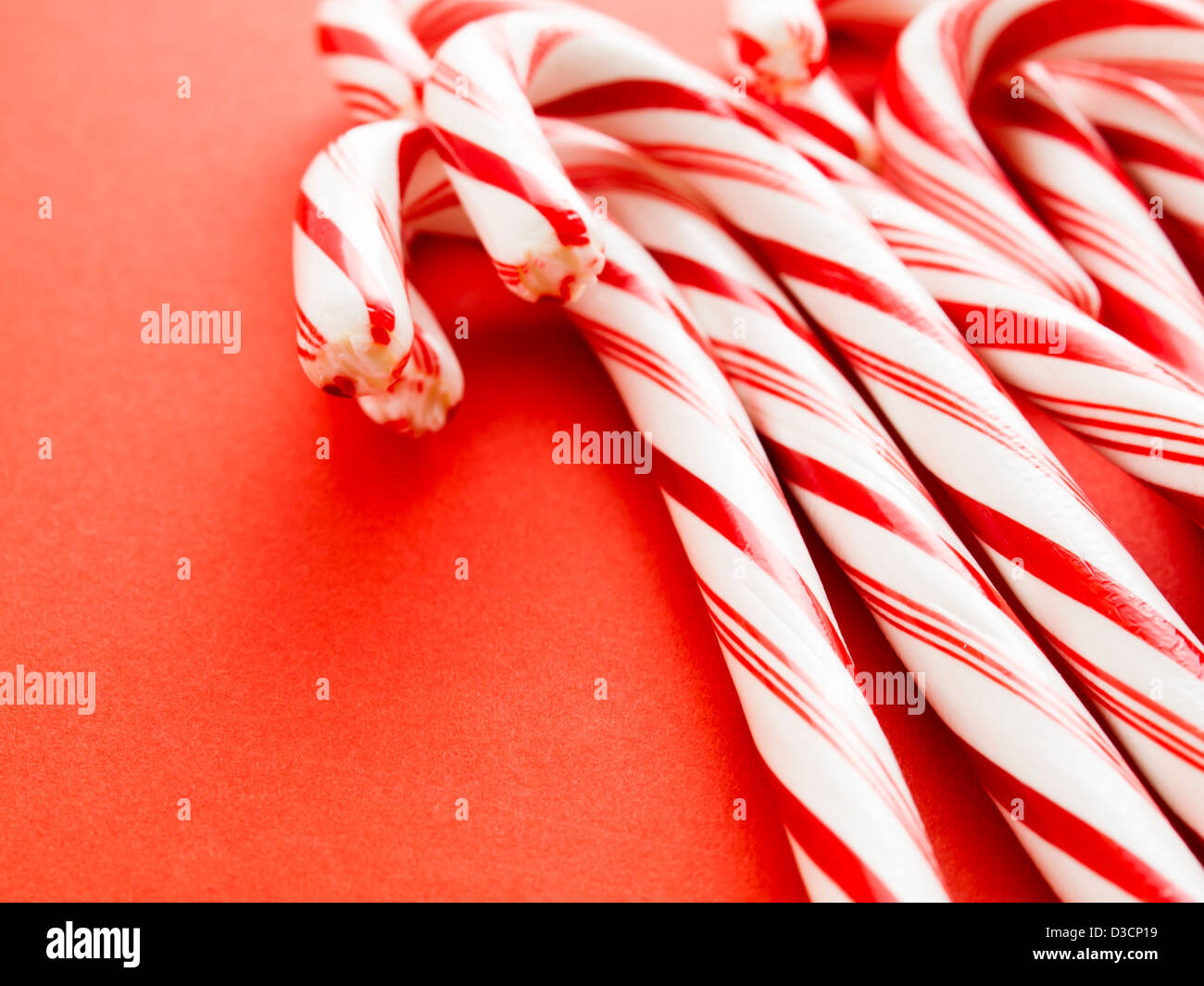 White and red peppermint candy canes on red background Stock Photo - Alamy