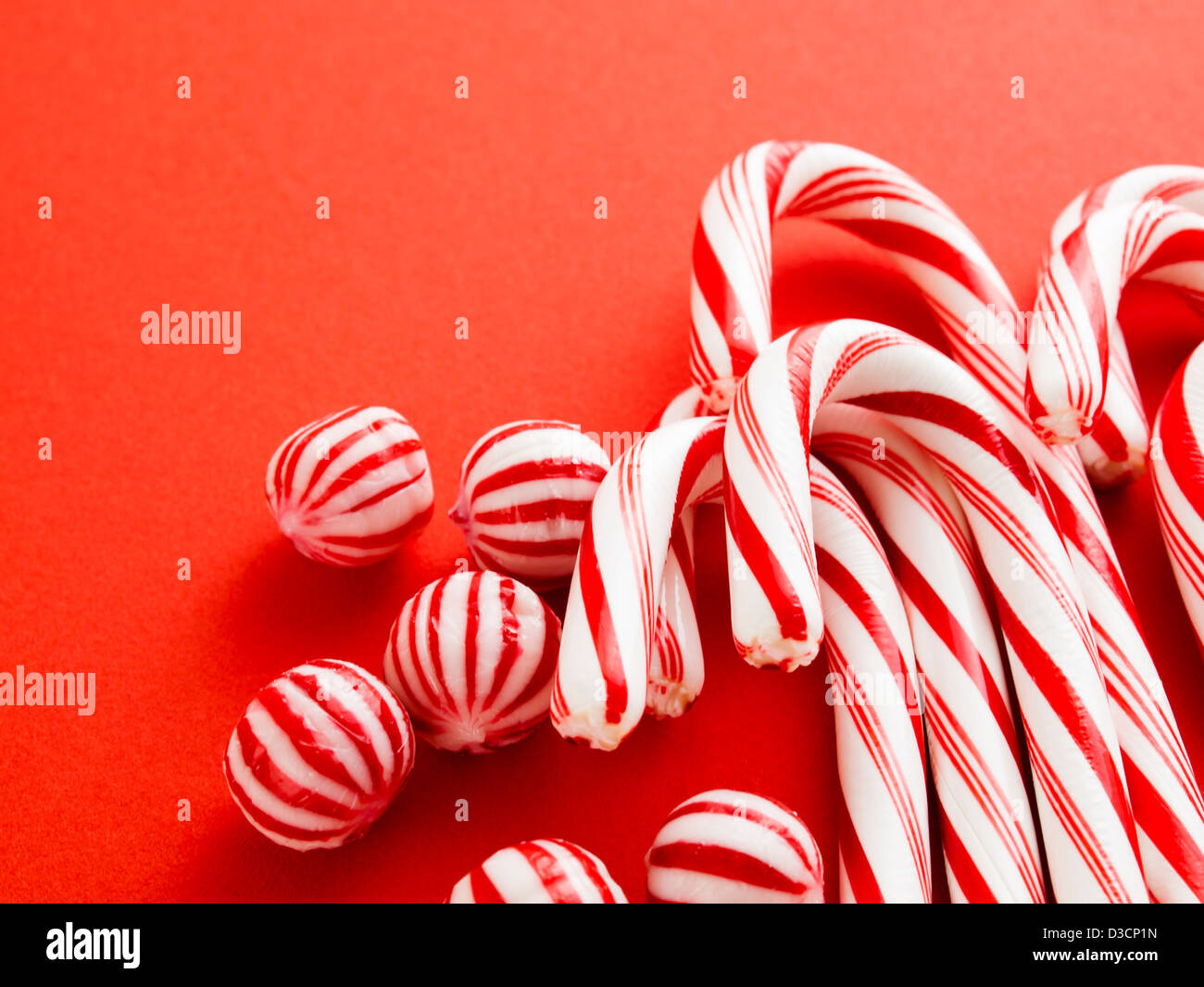 White and red peppermint candy canes on red background Stock Photo - Alamy