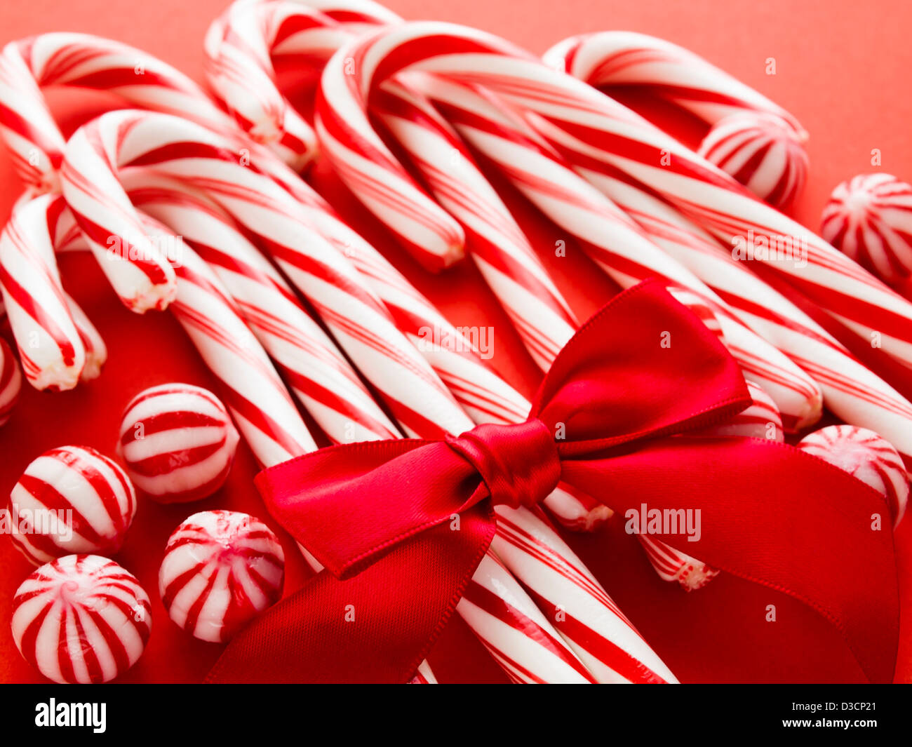 White and red peppermint candy canes on red background Stock Photo - Alamy