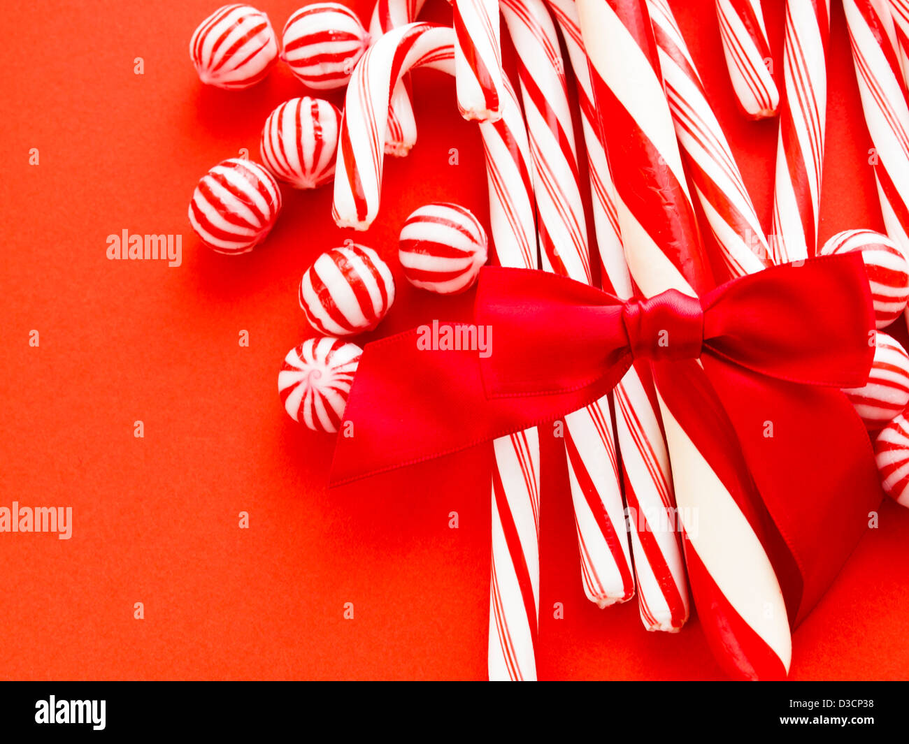 White and red peppermint candy canes on red background Stock Photo - Alamy