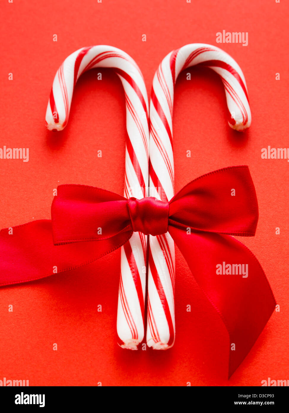 White and red peppermint candy canes on red background Stock Photo - Alamy