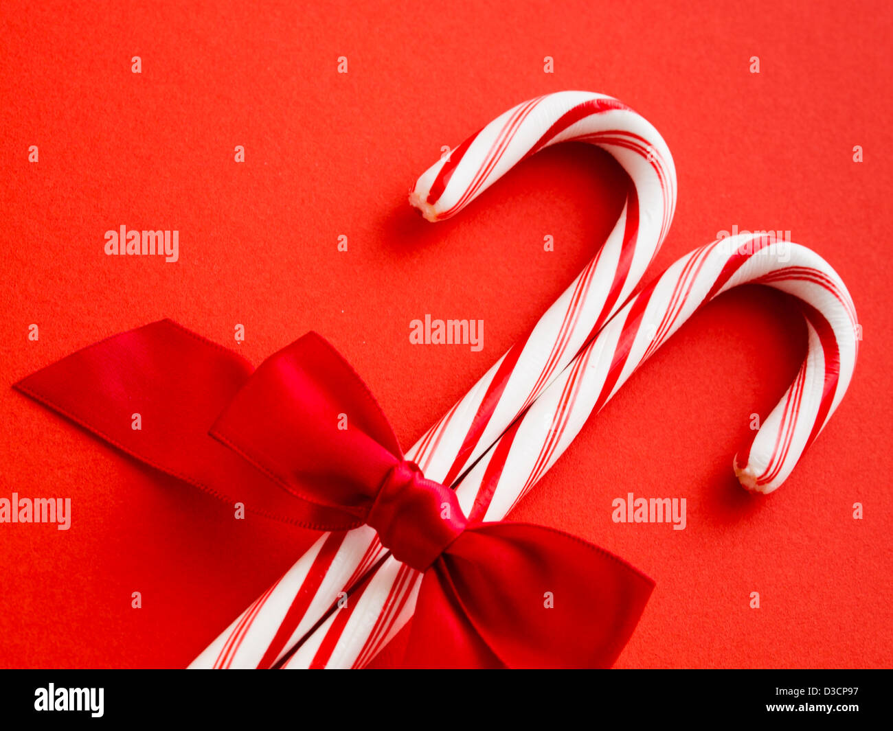 White and red peppermint candy canes on red background Stock Photo - Alamy