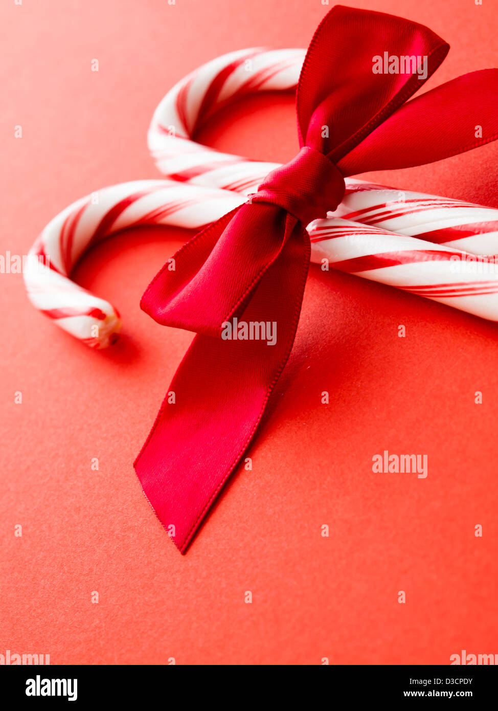 White and red peppermint candy canes on red background Stock Photo - Alamy