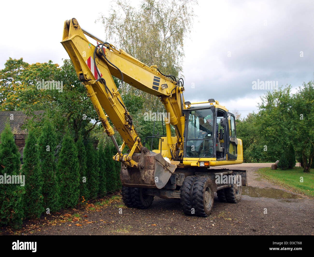 Hydraulic excavator driving and working on country farm Stock Photo - Alamy