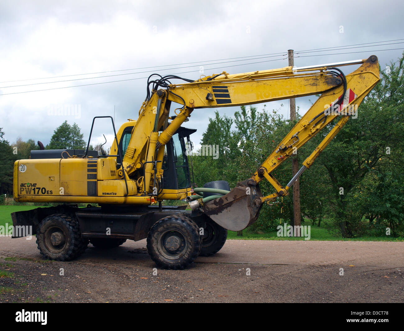 Hydraulic excavator driving and working on country farm Stock Photo - Alamy